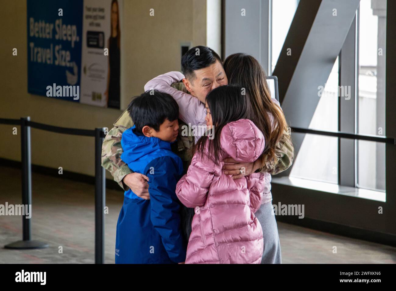 Capt. Marc Ueda embraces his family, while being welcomed home, Jan. 13 ...