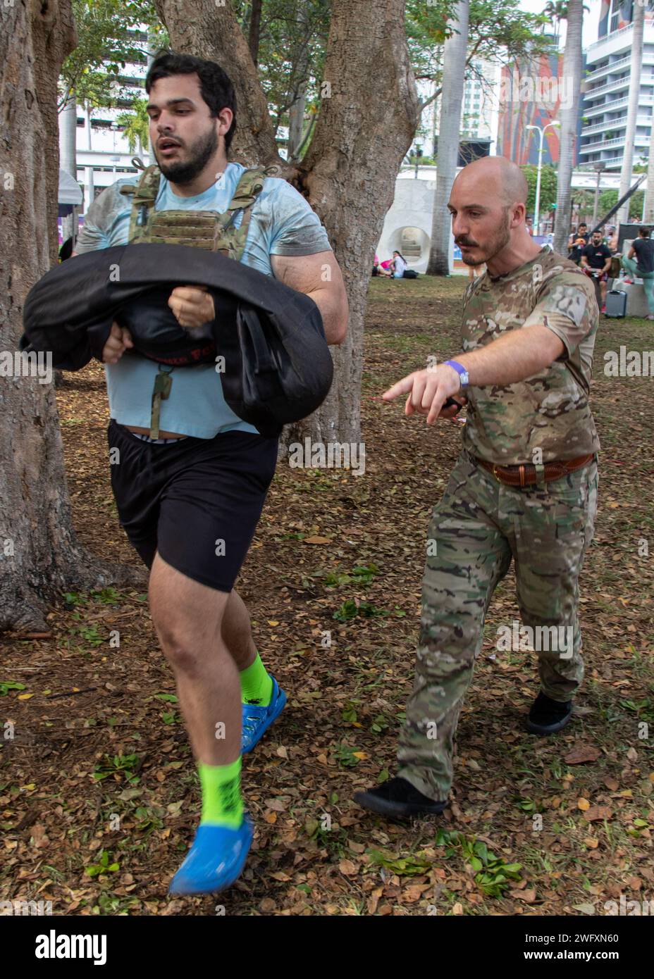 240113-N-LW994-1071 – MIAMI (Jan. 13, 2024) - A Navy SEAL guides a man ...