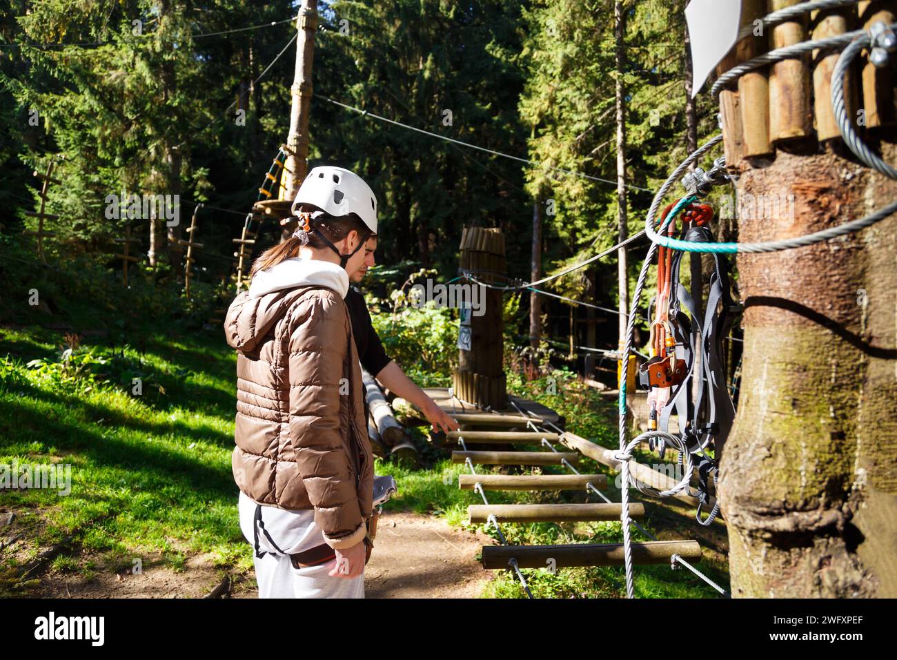 Trained instructor explains to girl rules of behavior in adventure park ...