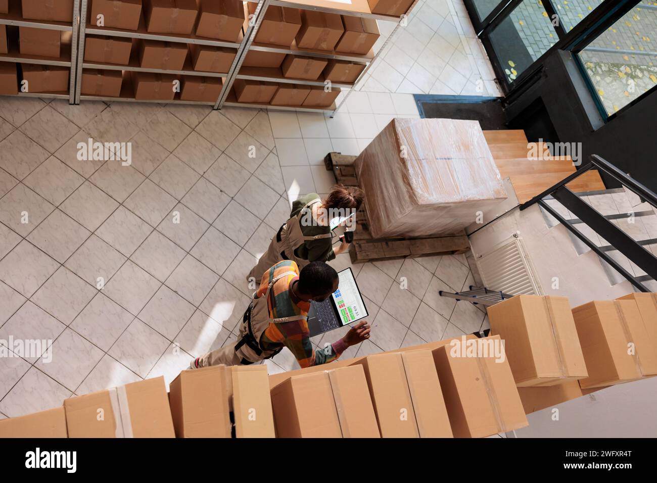 Diverse employees tracking clients online orders, checking warehouse ...