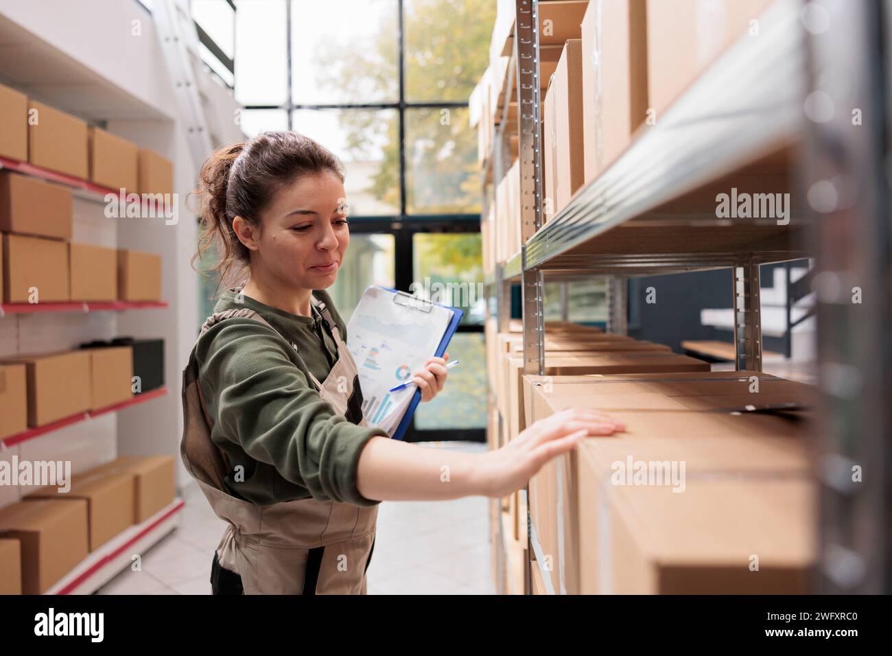Warehouse supervisor checking cardboard boxes barcode, preparing ...