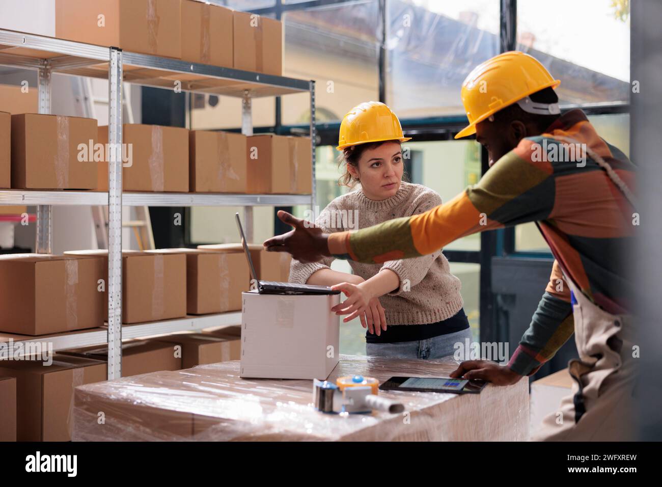 Warehouse coworkers preparing clients packages using cardboard boxes ...