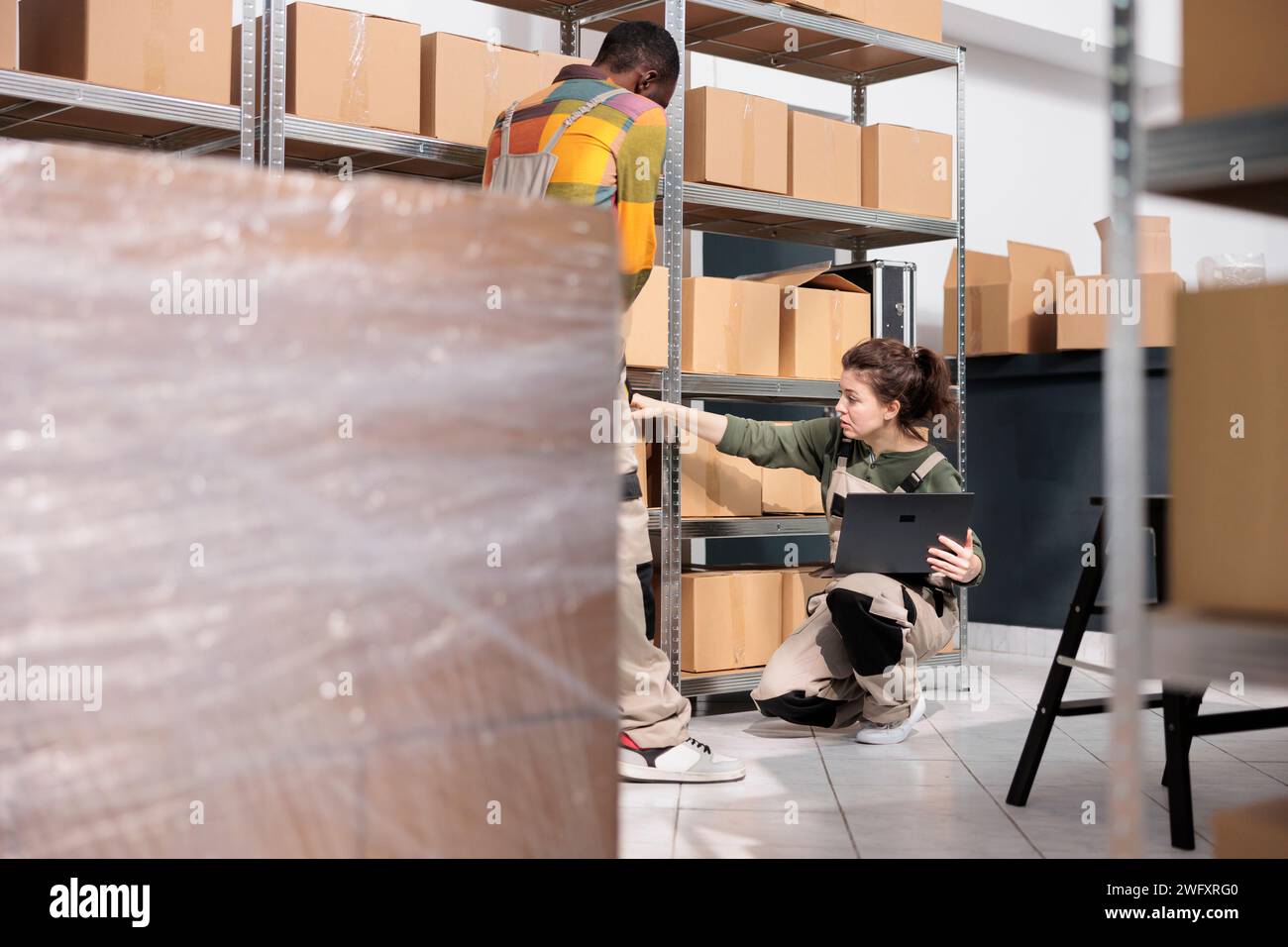 Delivery warehouse employees packing cardboard box and searching parcel ...
