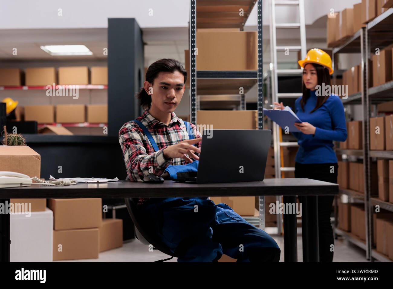 Young asian delivery service worker monitoring parcel transportation on ...