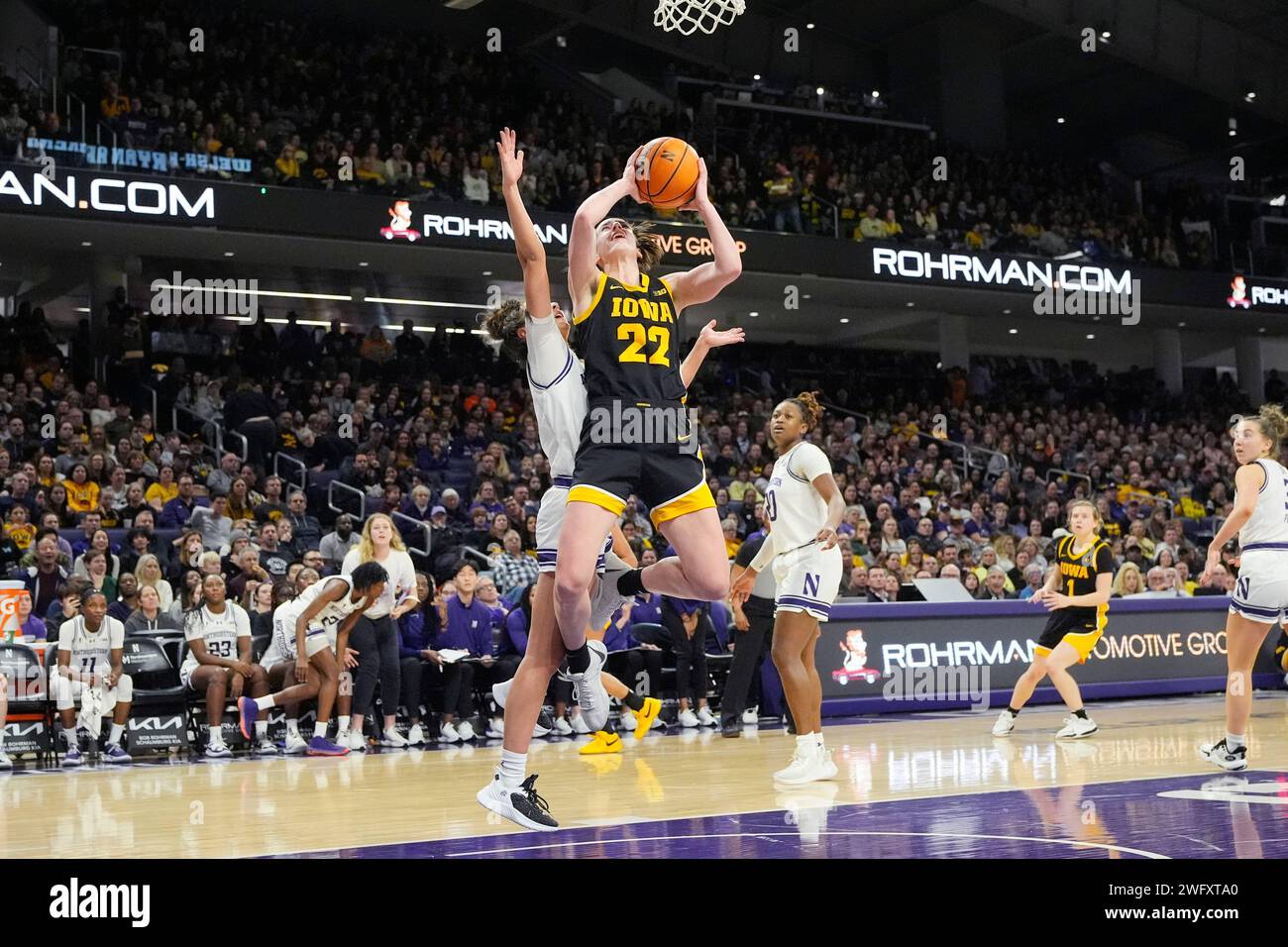Iowa guard Caitlin Clark, right, drives to the basket as Northwestern ...