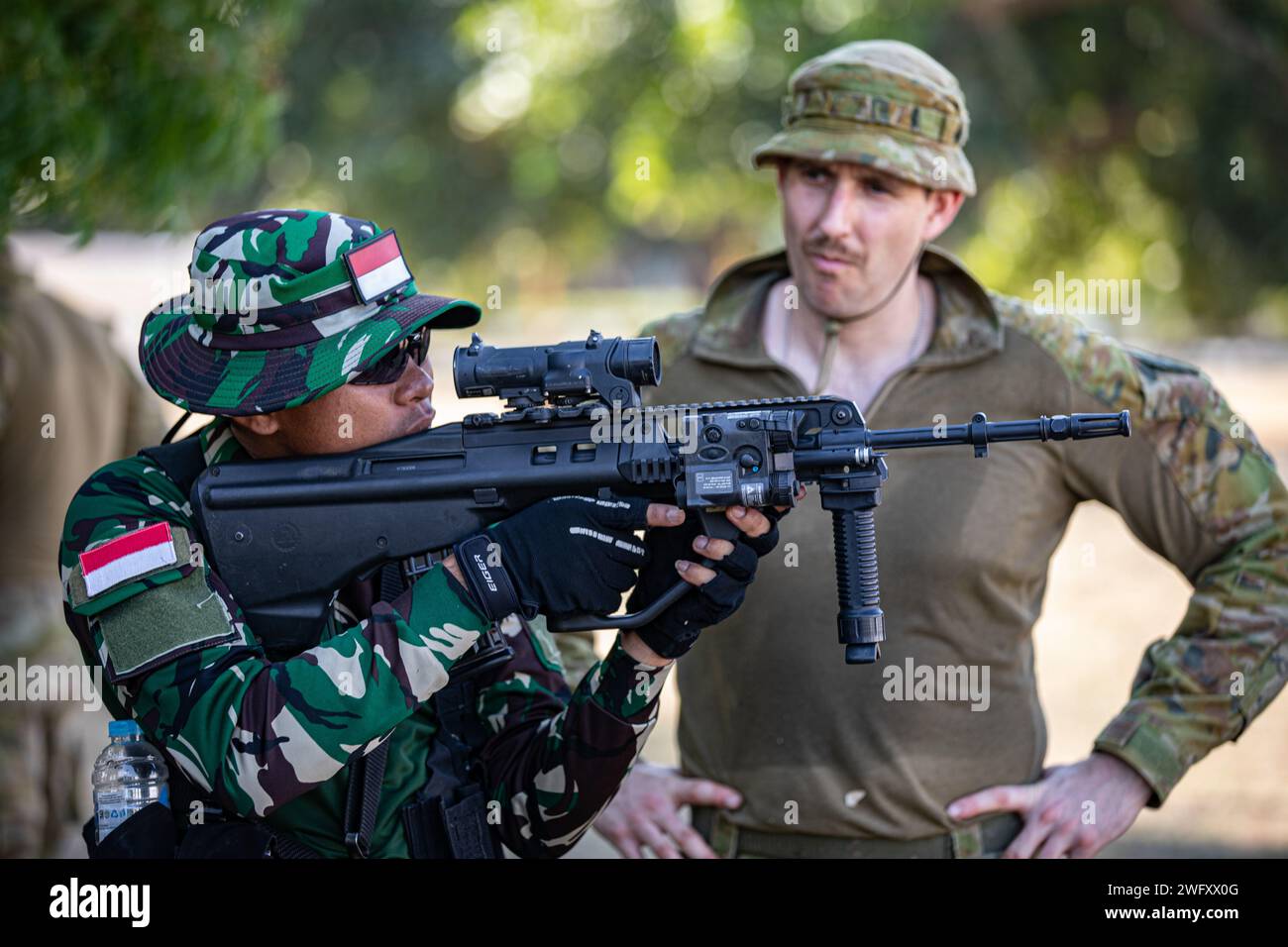 An Australian Soldier shows a Indonesian Service Member his EF88 ...