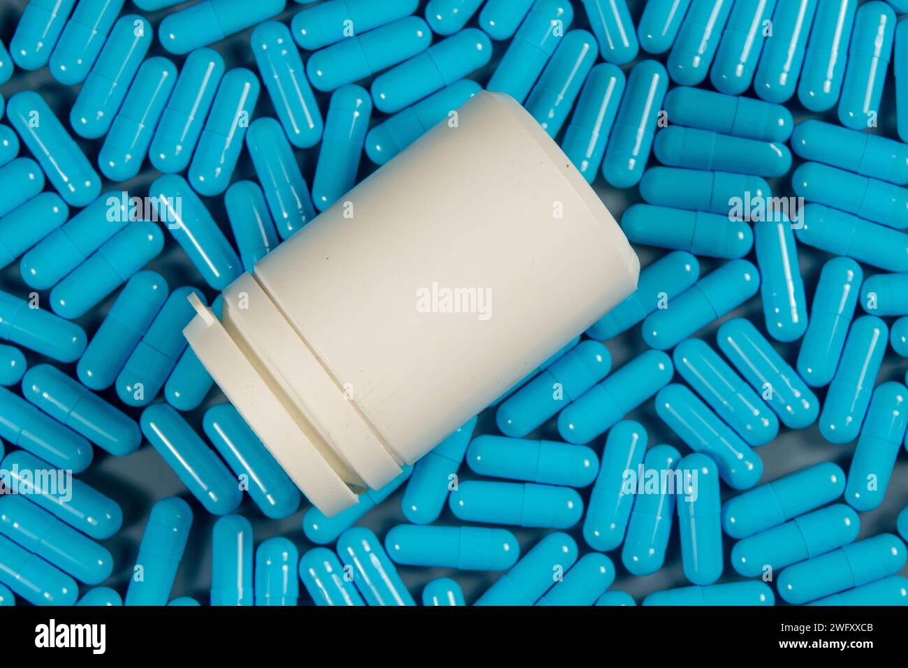 Blue antibiotic capsule pills texture with white bottle. Pharmaceutical ...