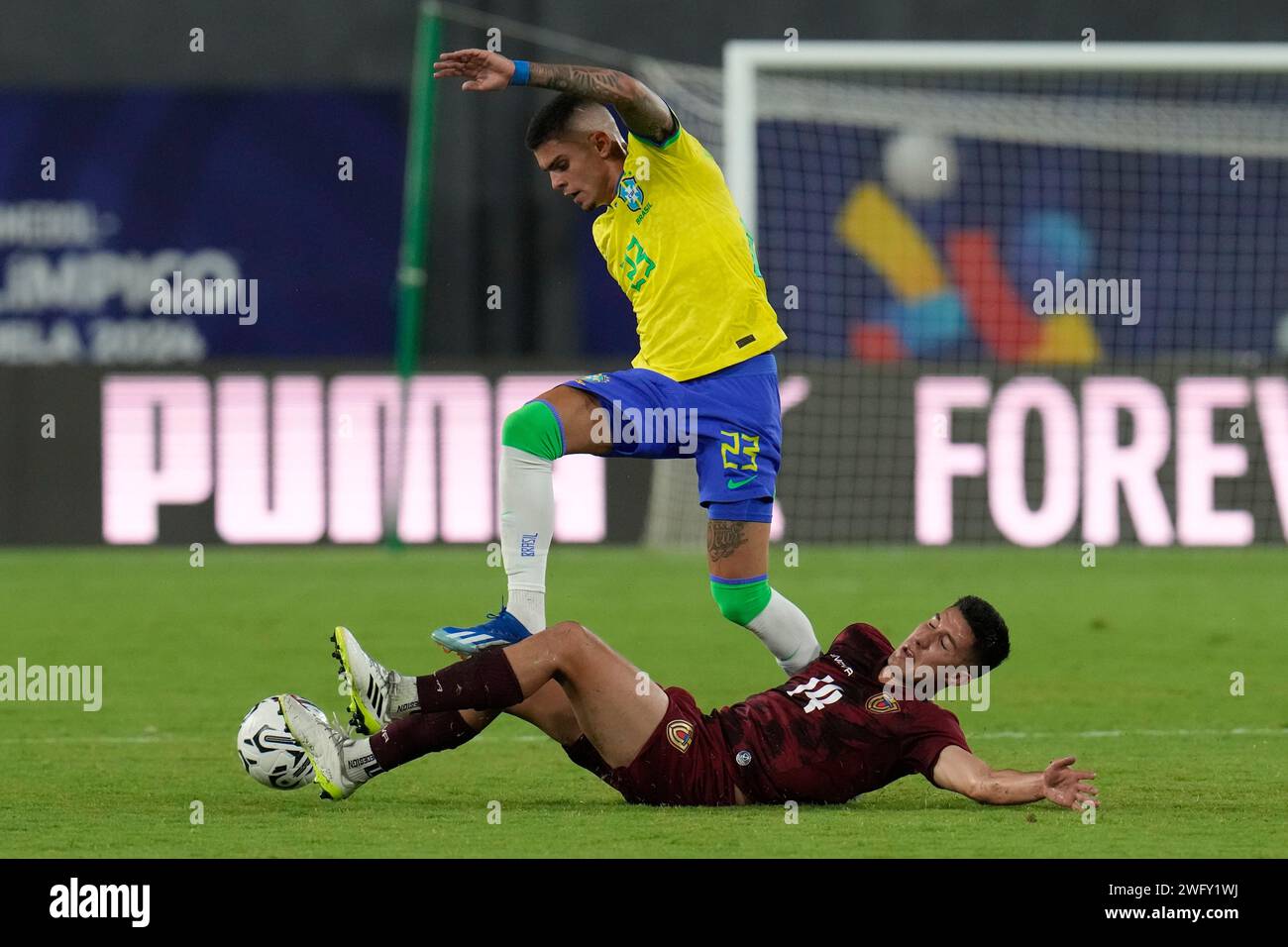 Brazil's Gabriel Pec, top, jumps over Venezuela's Carlos Faya during ...