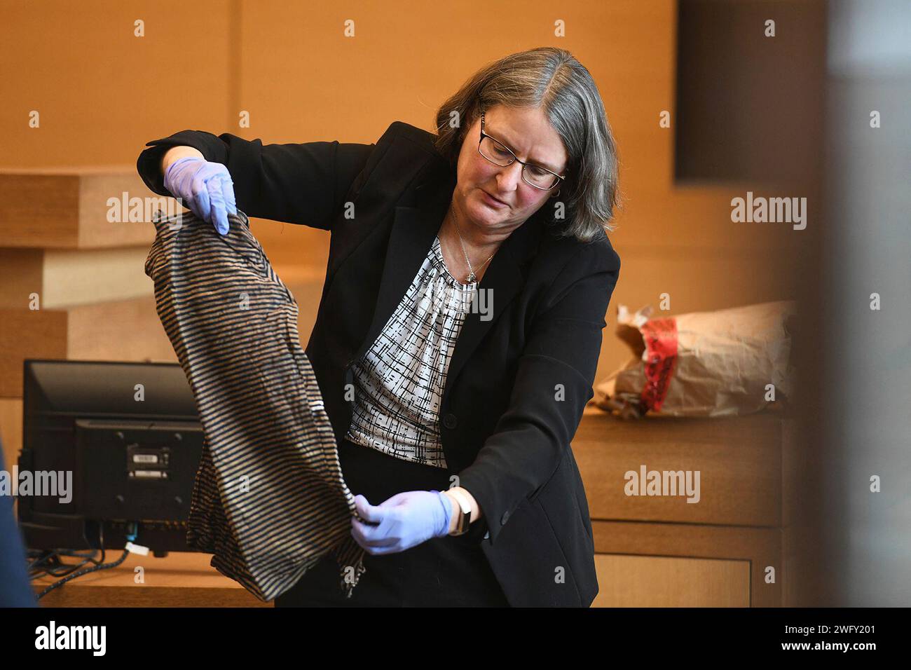 Christine Roy, retired state forensic science examiner, holds a shirt ...