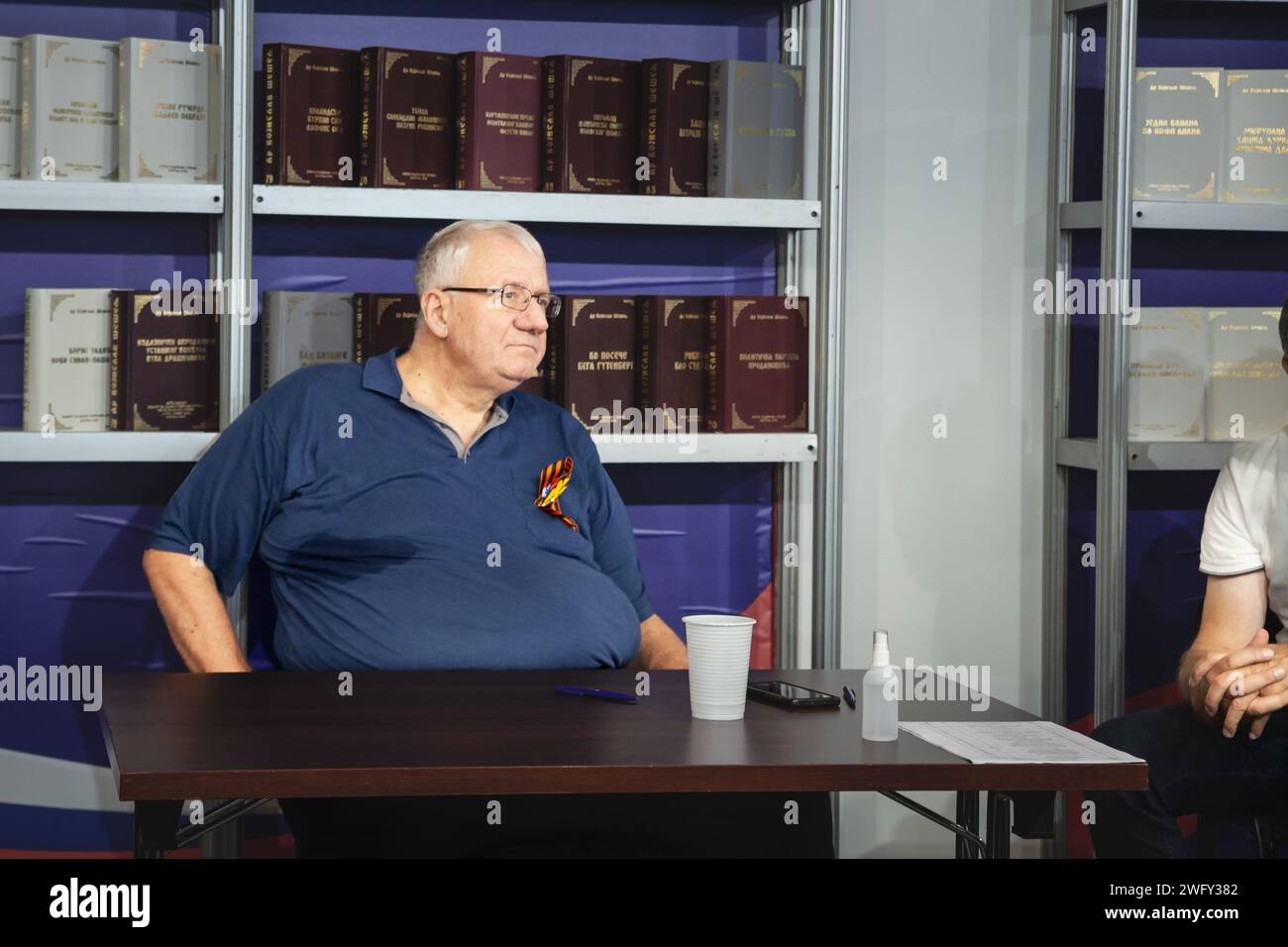 Picture of Vojislav Seselj standing in front of some of the books he ...
