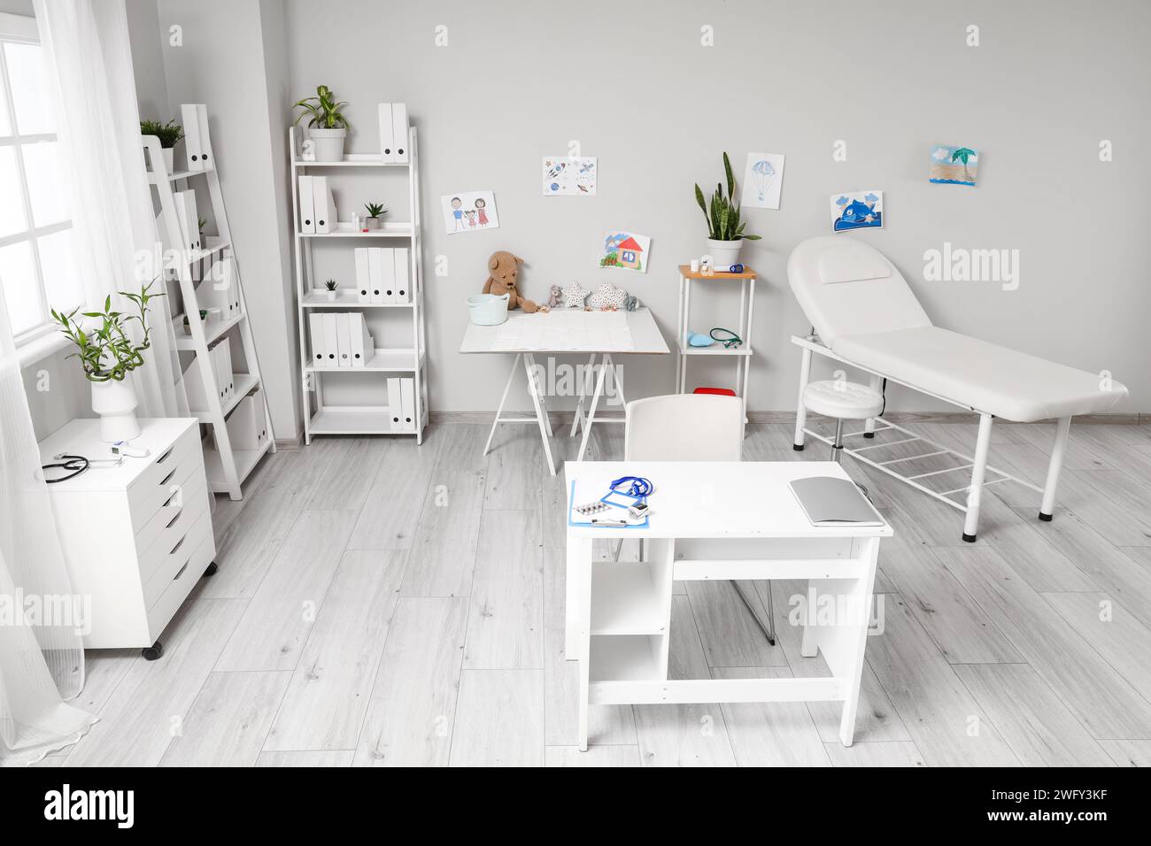 Interior of pediatrician's office with table, couch and children's ...