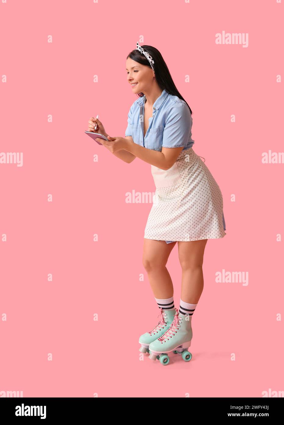 Beautiful young waitress with notebook on roller skates against pink ...