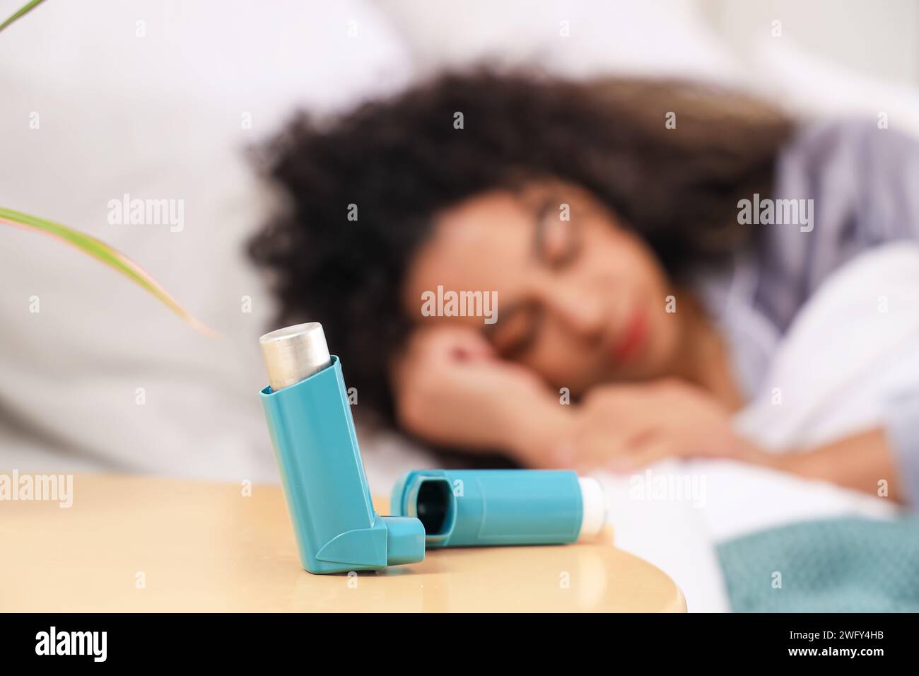 Asthma inhaler on table of sleeping woman in bedroom, closeup Stock ...
