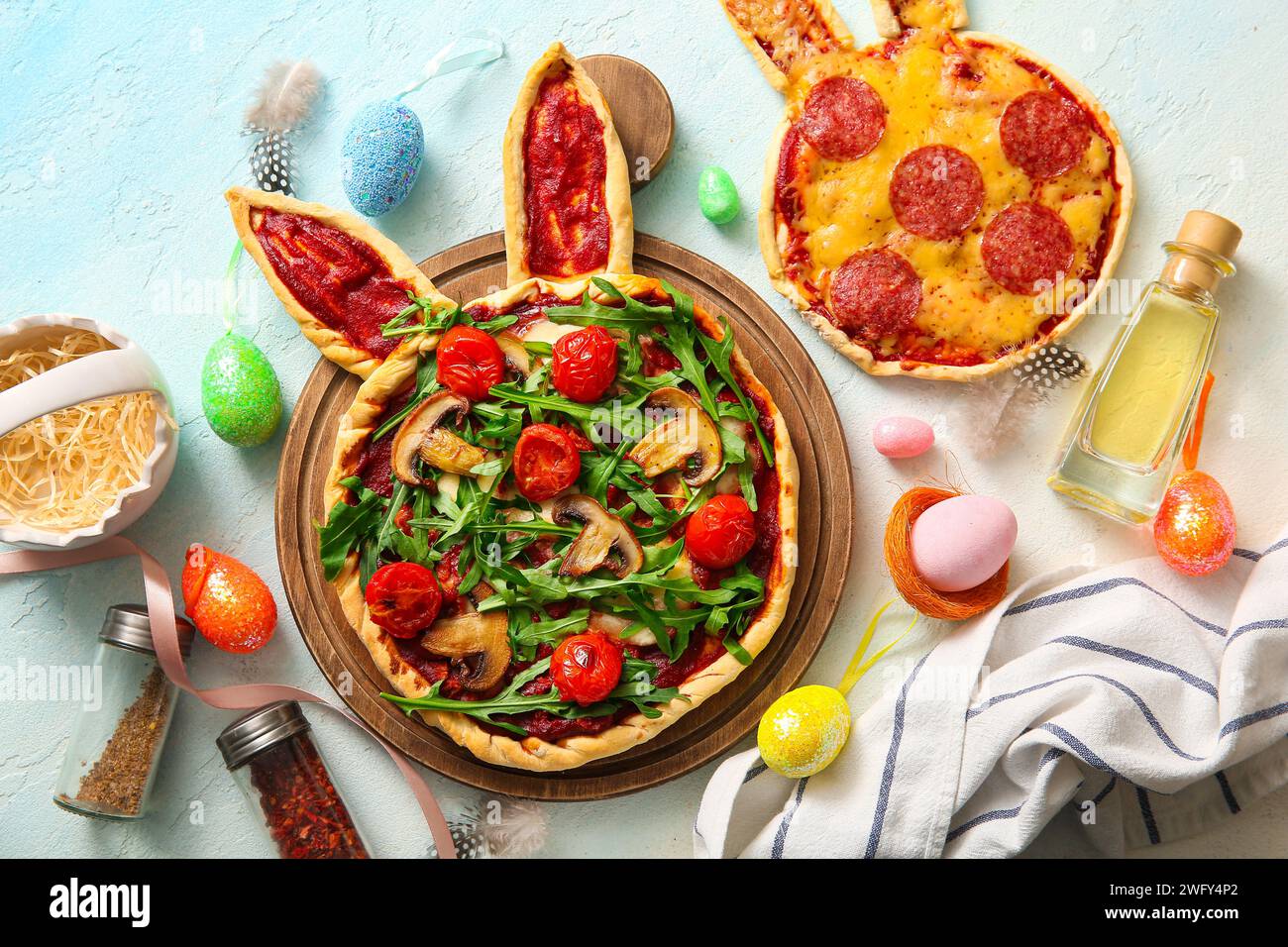 Composition with tasty pizzas and eggs for Easter celebration on blue ...