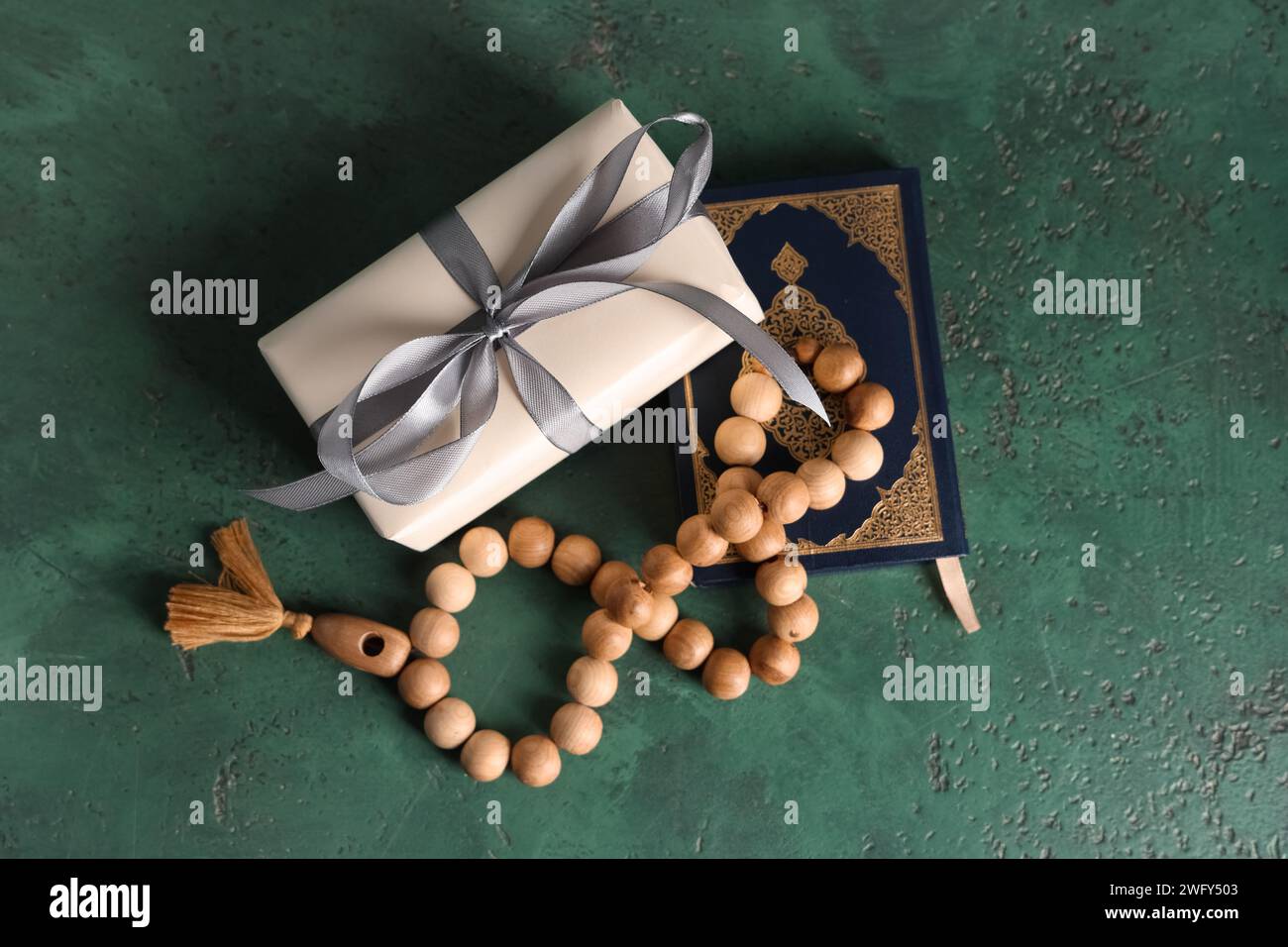 Gift box with Koran and prayer beads for Ramadan on green grunge ...