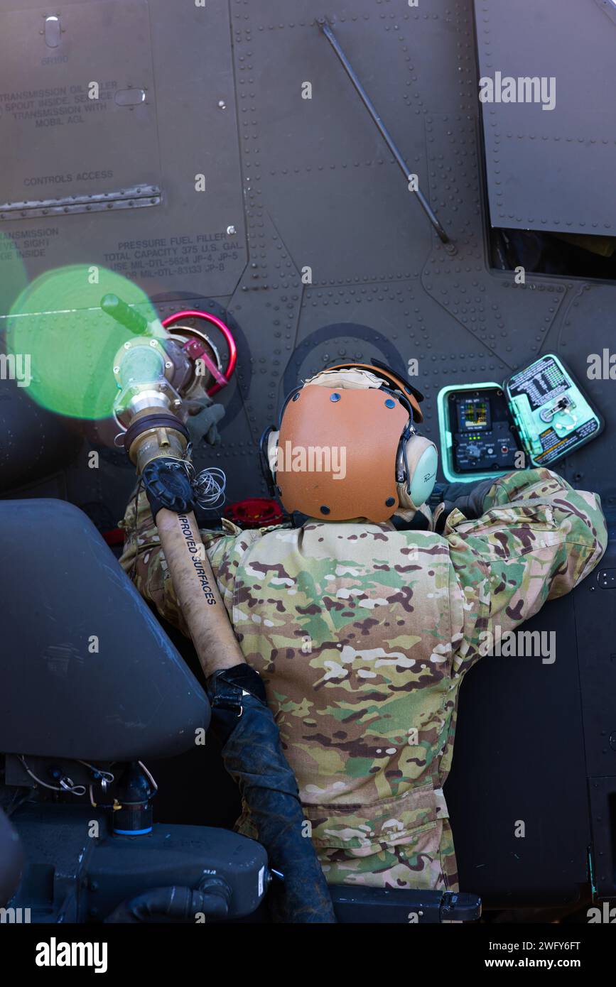 A U.S. Army Soldier refuels an AH-64E Apache during a forward arming ...
