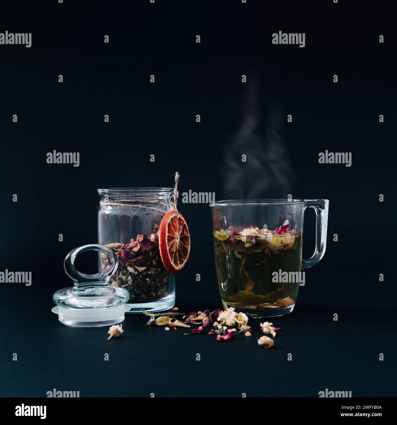 Creative layout made with cup of herbal tea with various herbs on dark ...