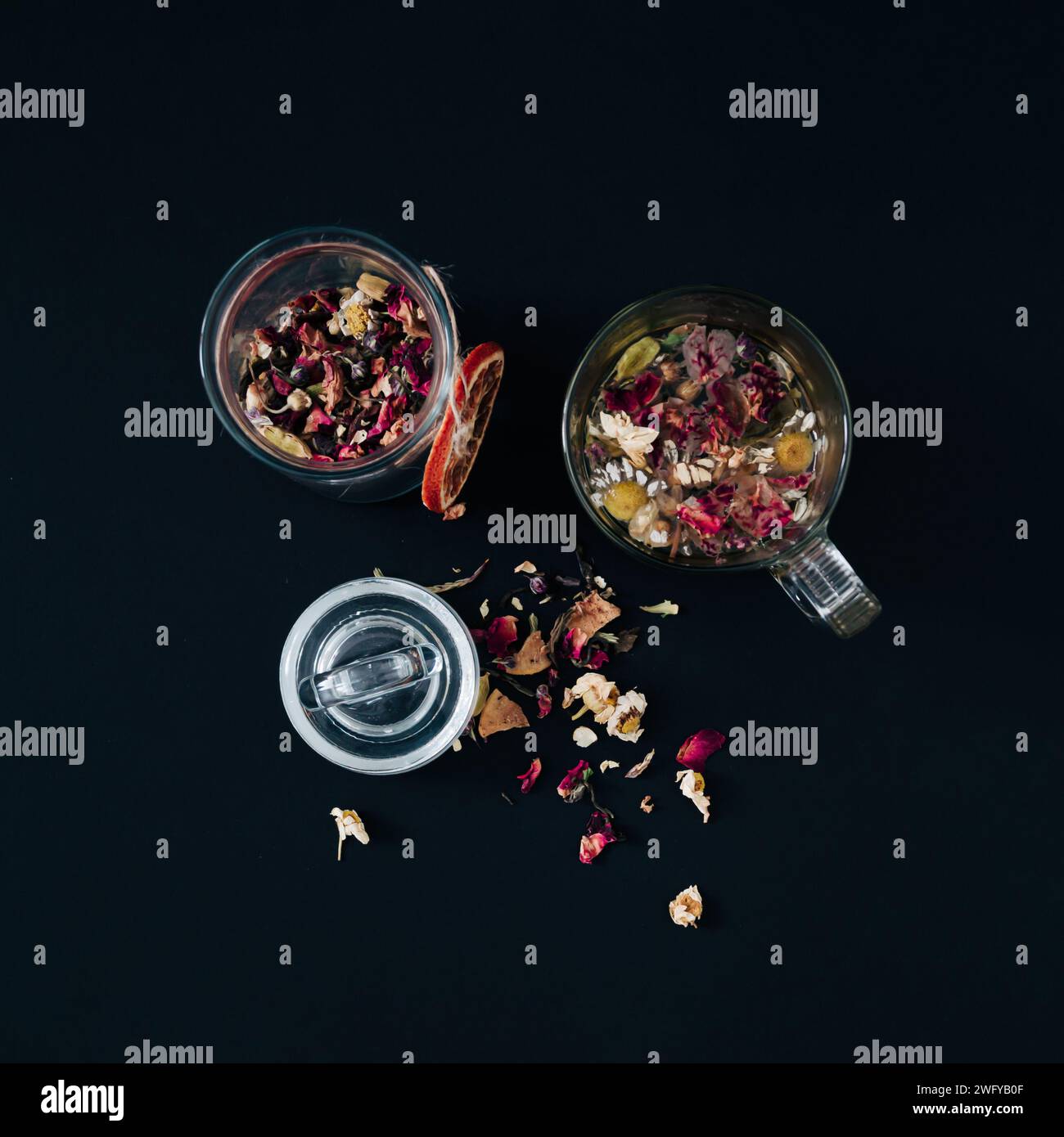 Creative layout made with cup of herbal tea with various herbs on dark ...