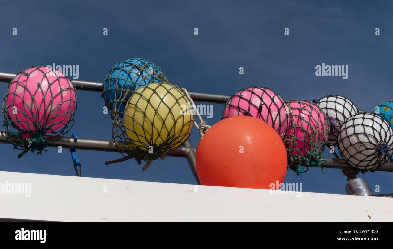 Marine marker buoys hanging on railings at Port Isaac, Cornwall, UK ...