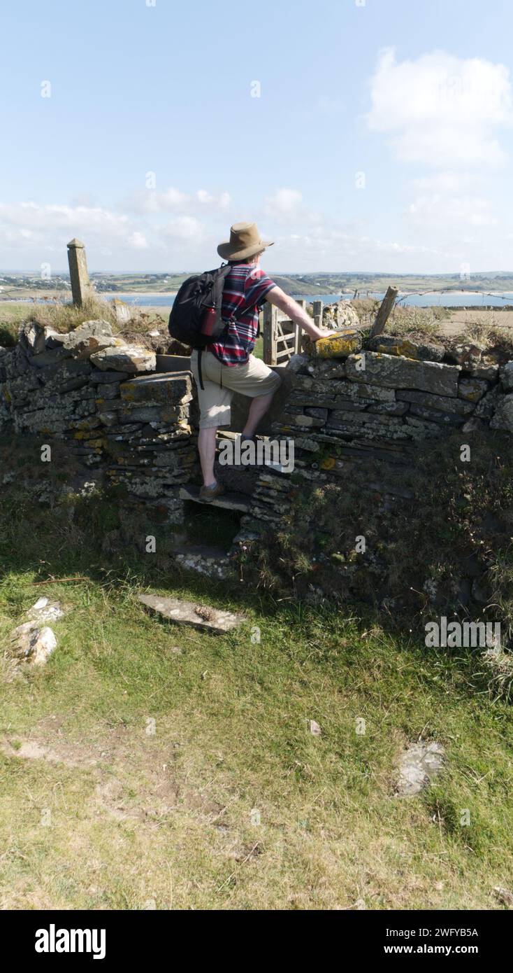 Walker climbing over an old stone stile in Cornwall, England, UK Stock ...