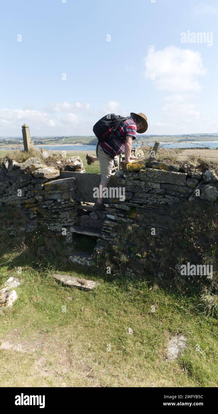 Walker climbing over an old stone stile in Cornwall, England, UK Stock ...