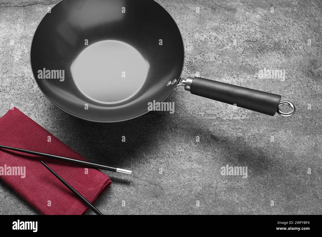 Empty iron wok and chopsticks on grey table Stock Photo - Alamy