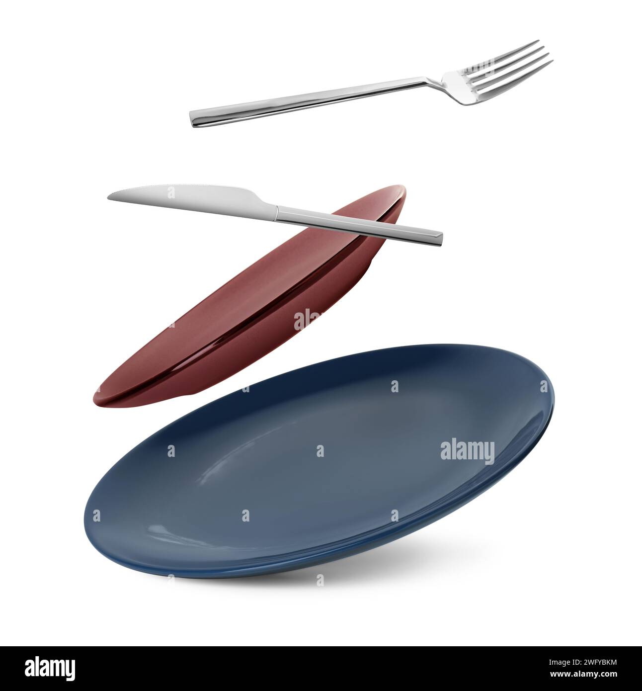 Clean plates, fork and knife falling on white background Stock Photo ...