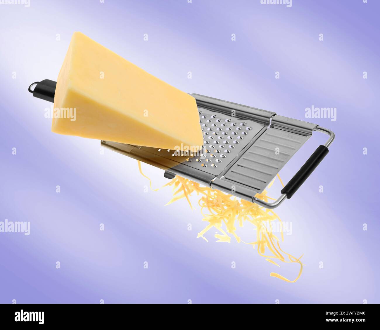 Grating cheese with hand grater on blue background Stock Photo - Alamy