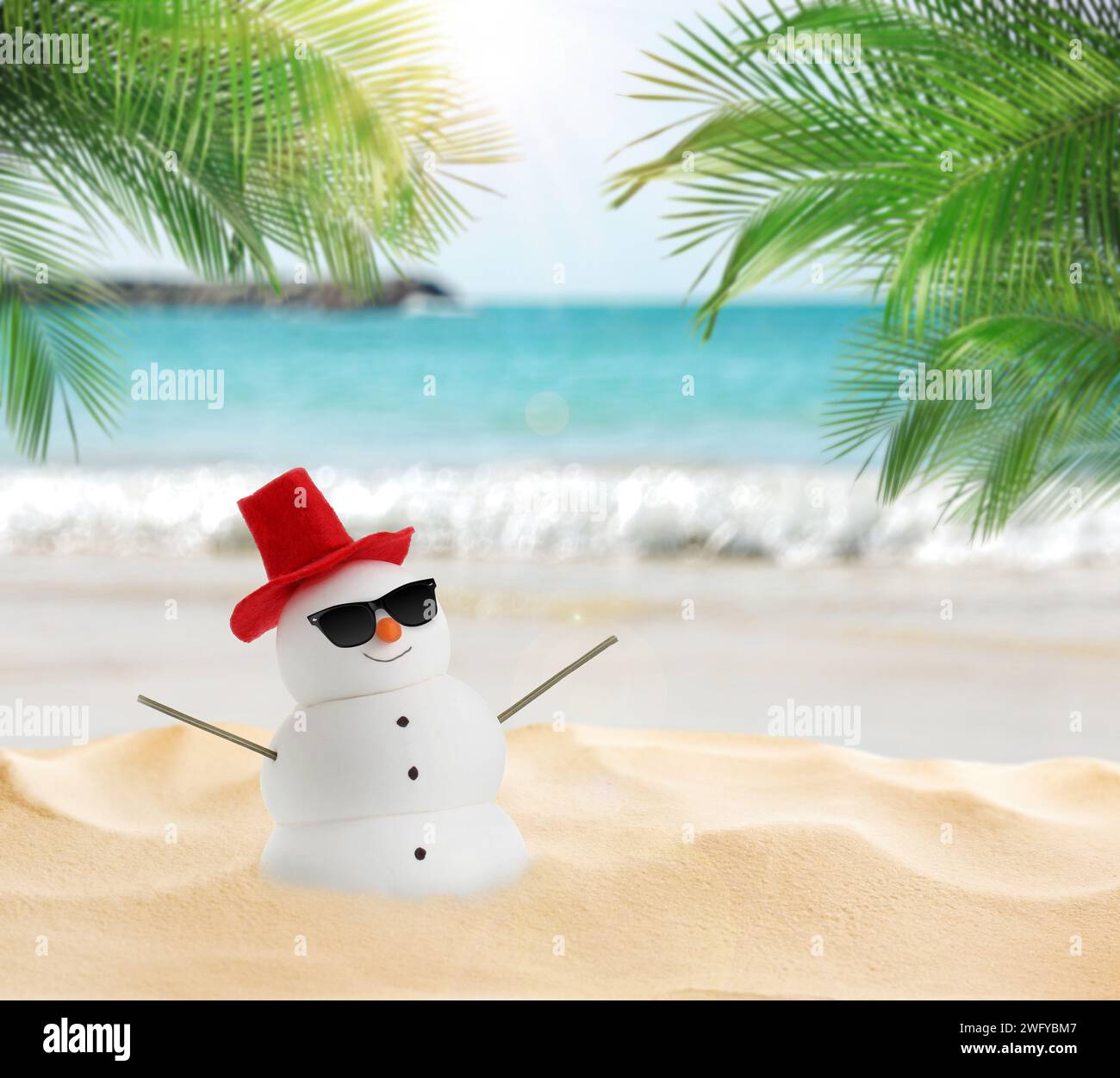 Cute small decorative snowman with sunglasses and red hat on sandy ...