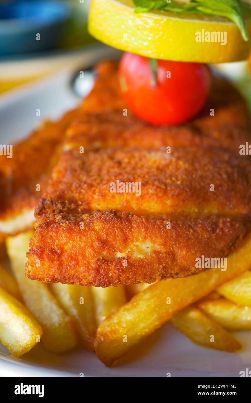 Chicken schnitzel served with potato chips Stock Photo - Alamy