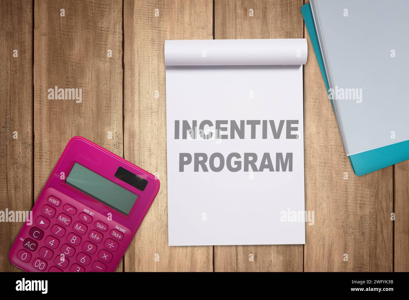 Calculator and notes with incentive program text on a wooden background ...