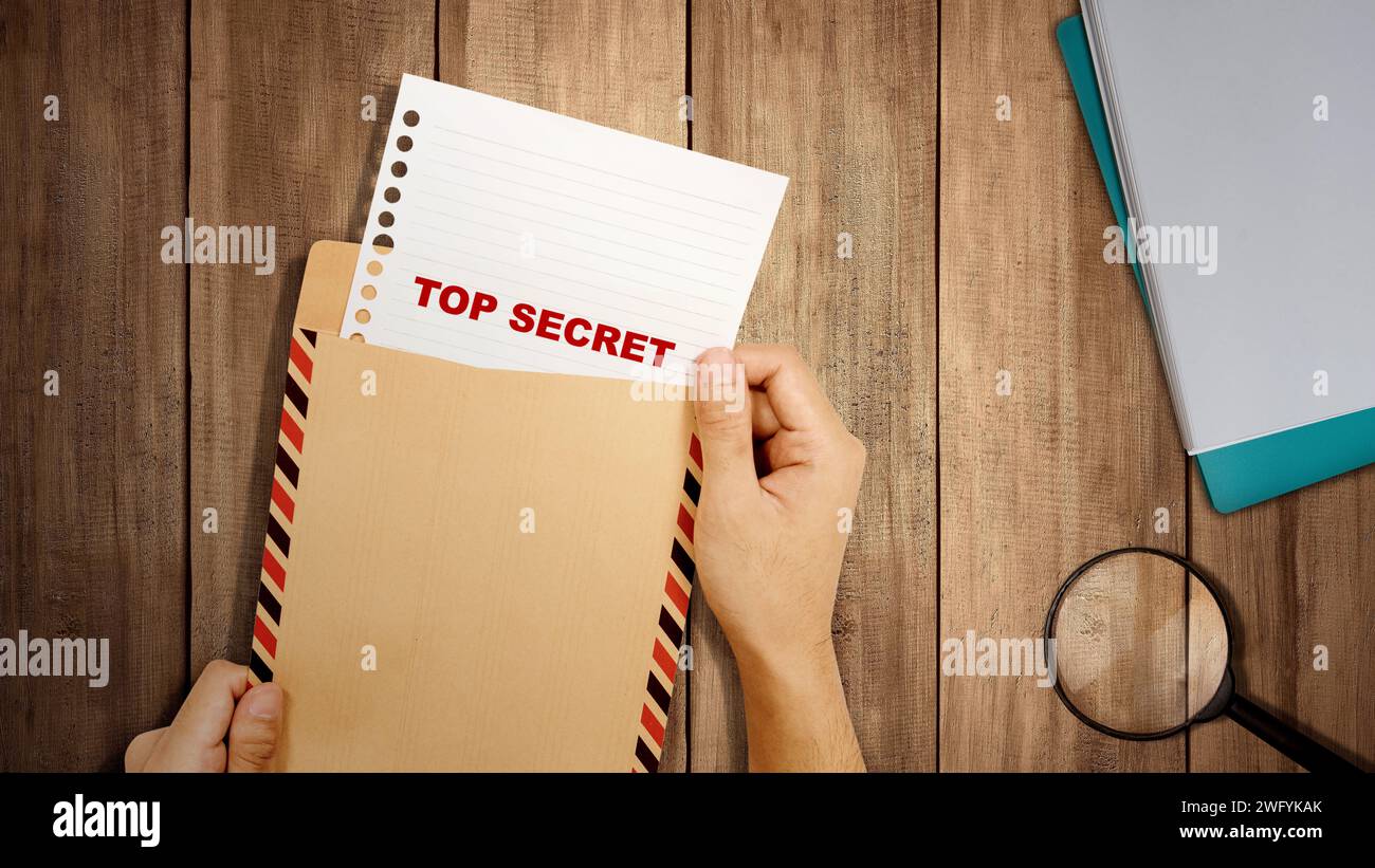 A human hand opens a brown envelope with the text of top-secret on the ...