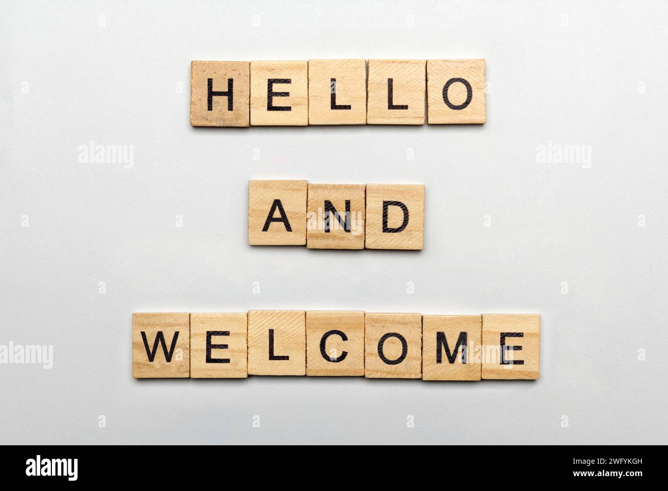 A row of wooden cubes with hello and welcome text over a white ...