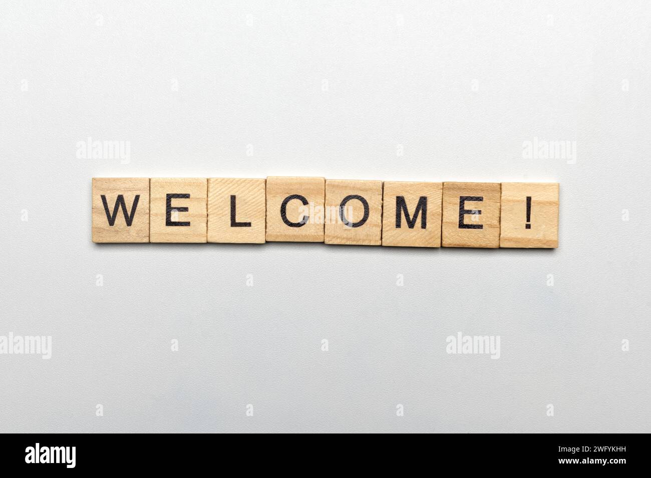 A row of wooden cubes with welcome text over a white background ...