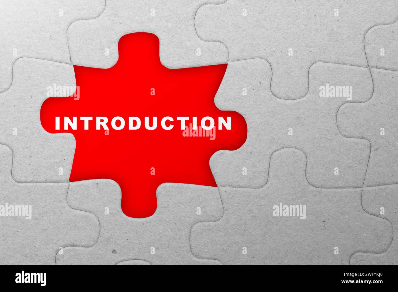 Piece of missing jigsaw puzzle with introduction text over red ...