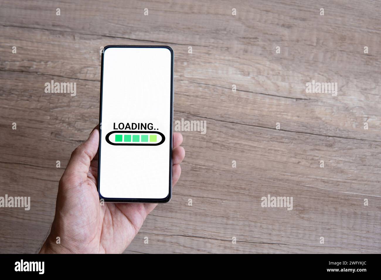 Hand holding smartphone with word LOADING. Copy space for text Stock ...