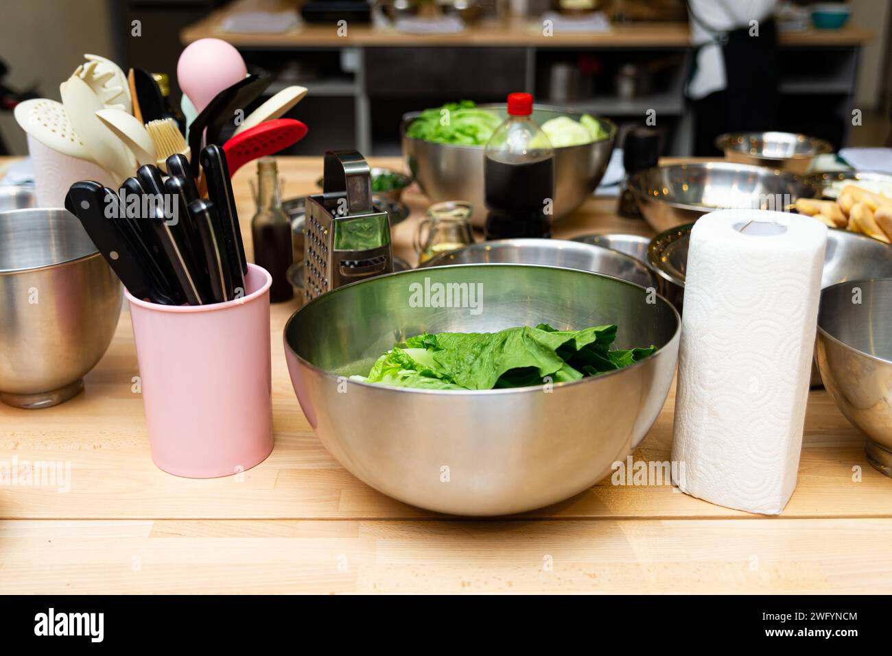 A well-equipped kitchen prep area with fresh greens in a large metal ...