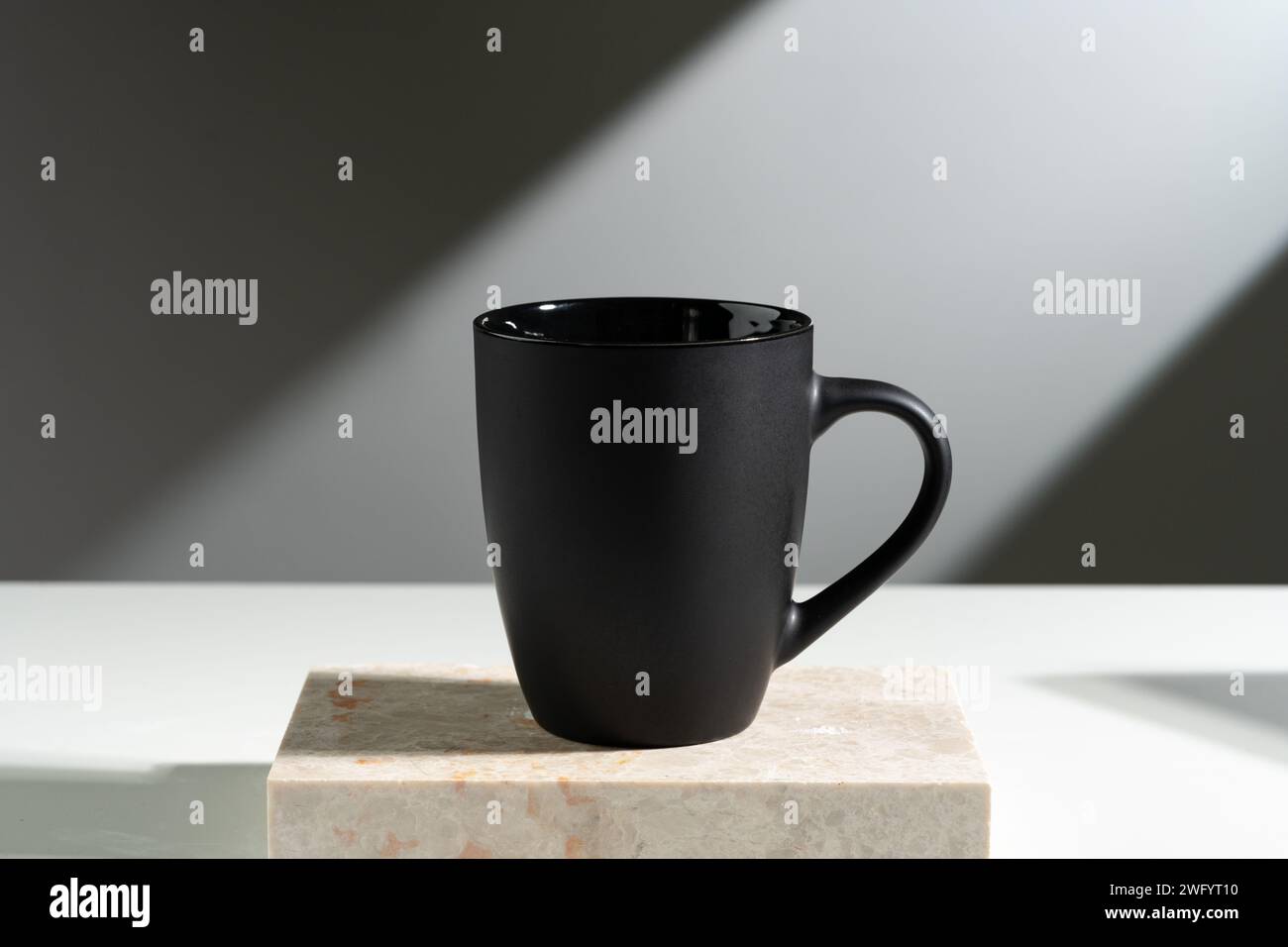 Black cup shadow sun light against gray background Stock Photo - Alamy