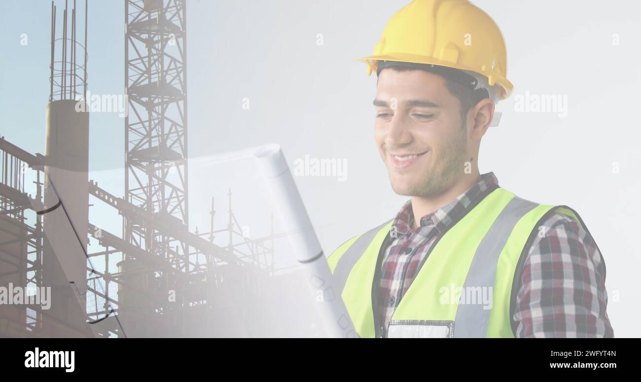 Image of caucasian male architect with plans over construction site ...