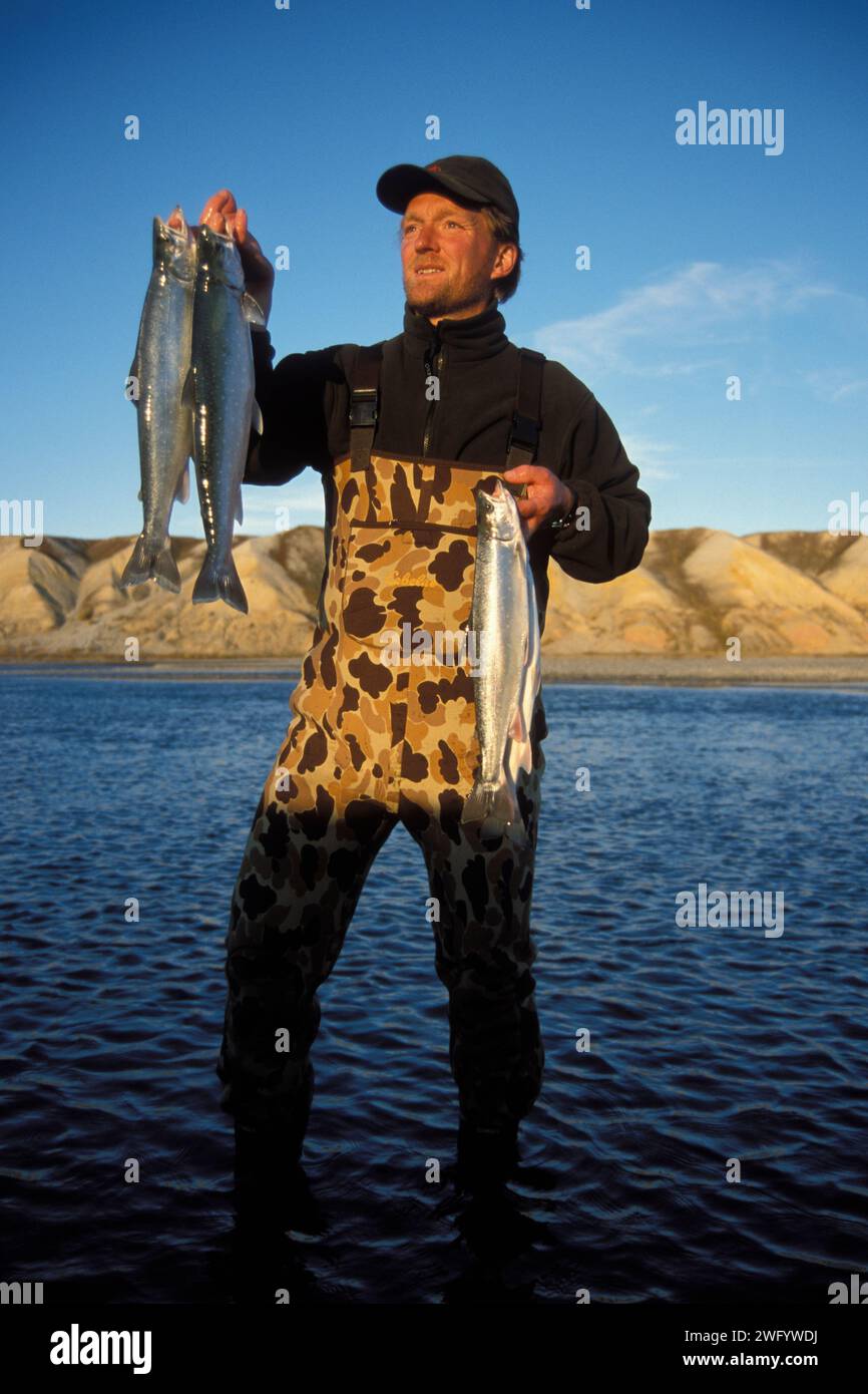sport fisherman holds up his catch of Arctic char, Salvelinus alpinus ...