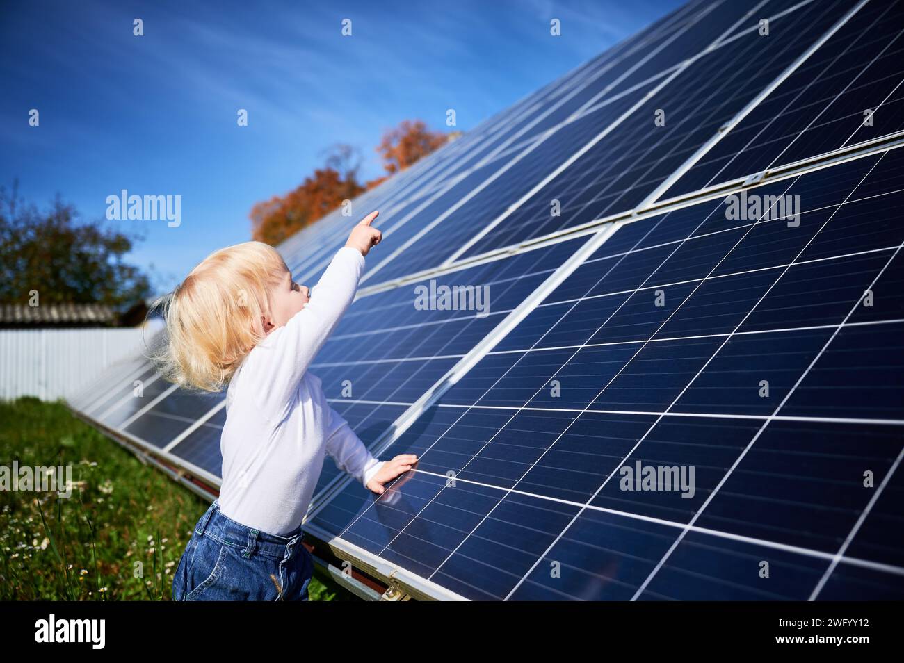 Little child looking at big solar panels. Interested boy investigates ...