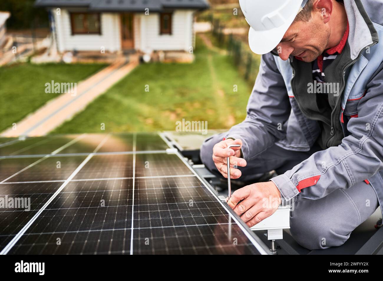 Man engineer mounting photovoltaic solar panels on roof of house ...