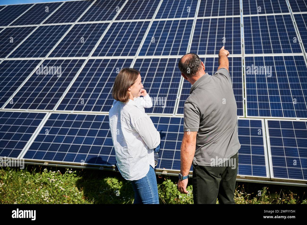 Happy father showing his wife and little son new solar panels. Young ...