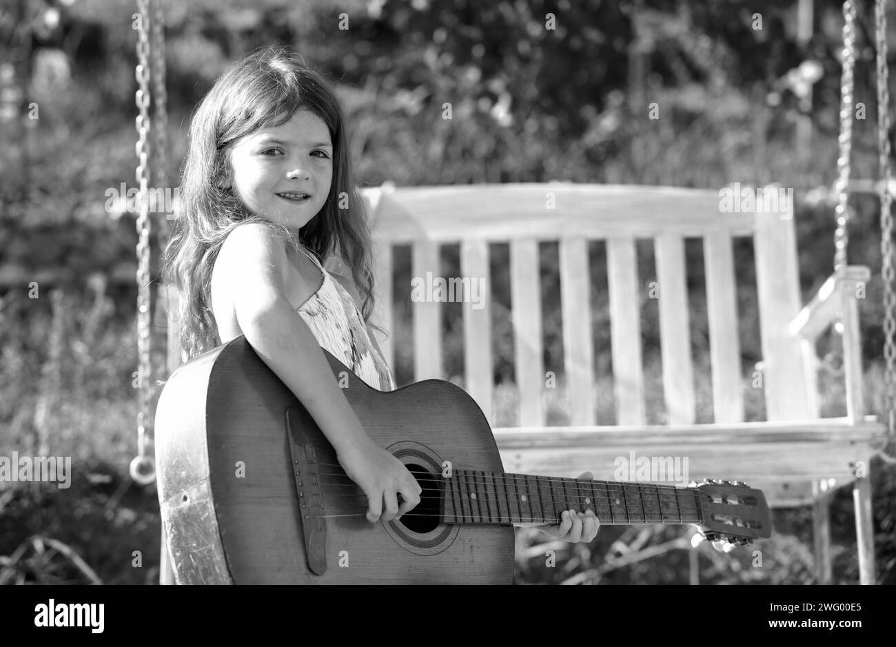 Happy smiling child girl play the guitar. Dreamy kids face. Smiling ...