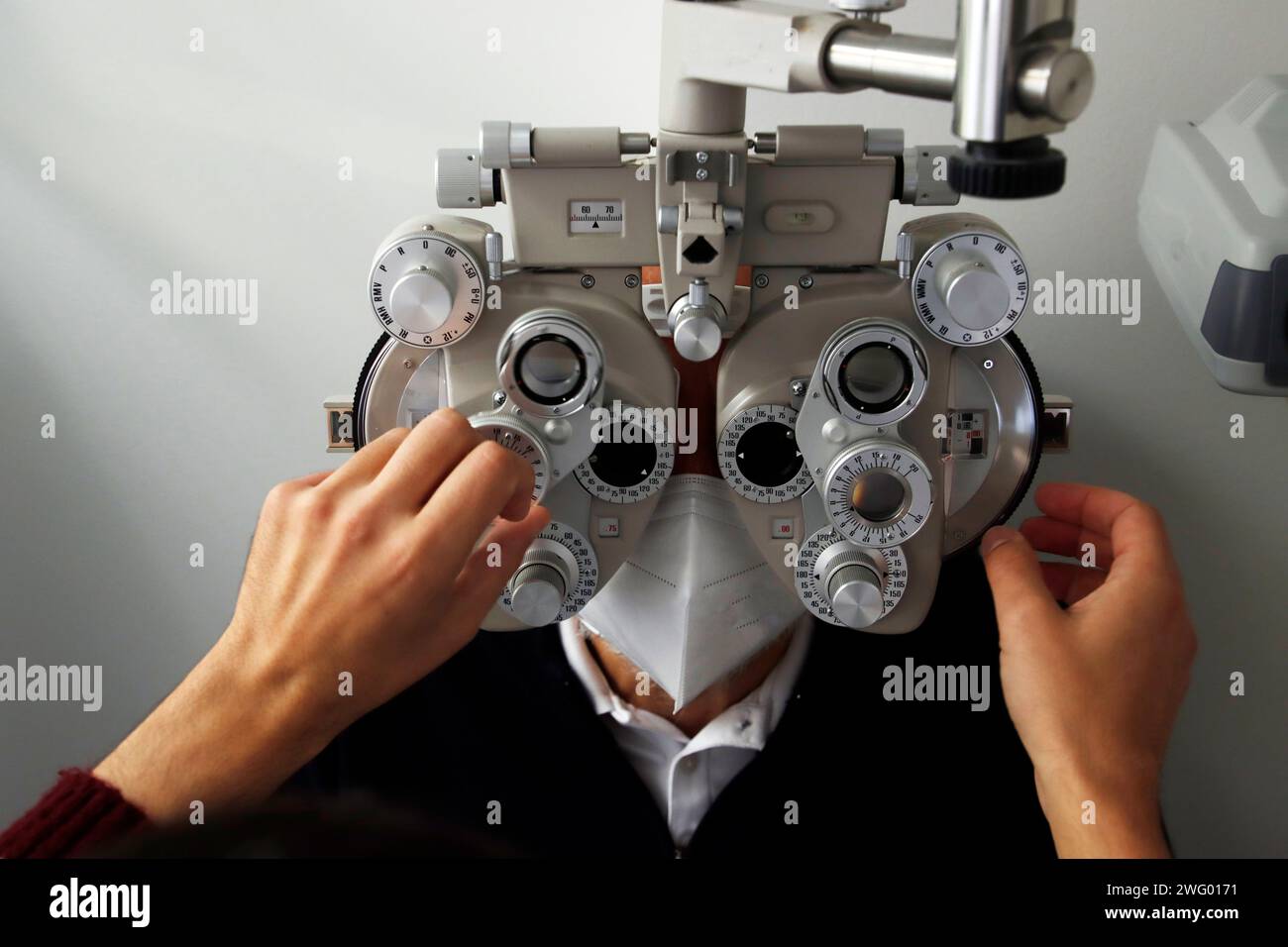 An opthalmologist examining a patient's eyes in a medical office Stock ...