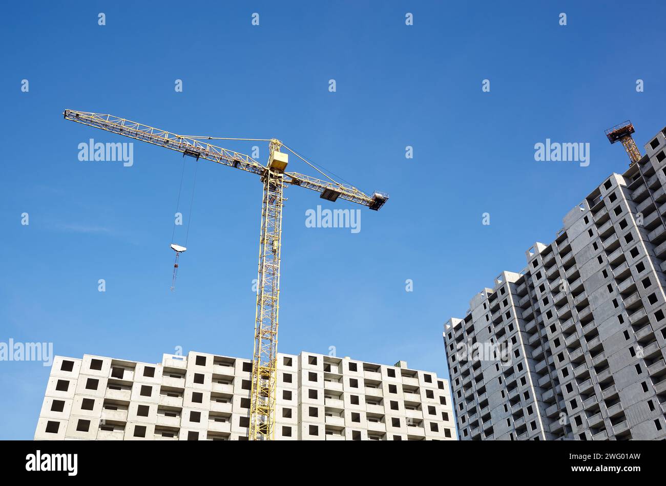 Tower crane building a house. Concrete building under construction ...