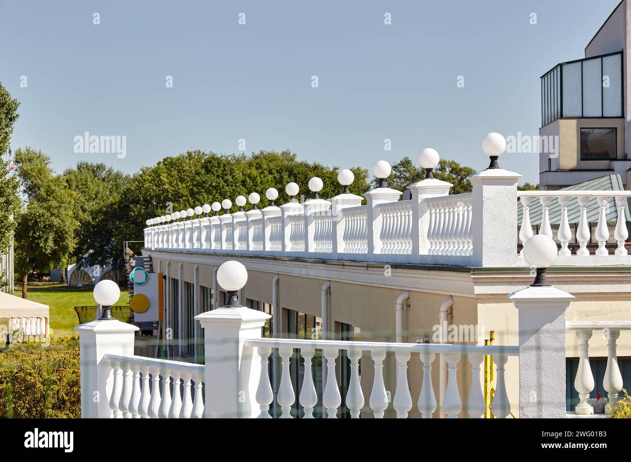 Fragment of the terrace with columns, lamps and railings. White stone ...