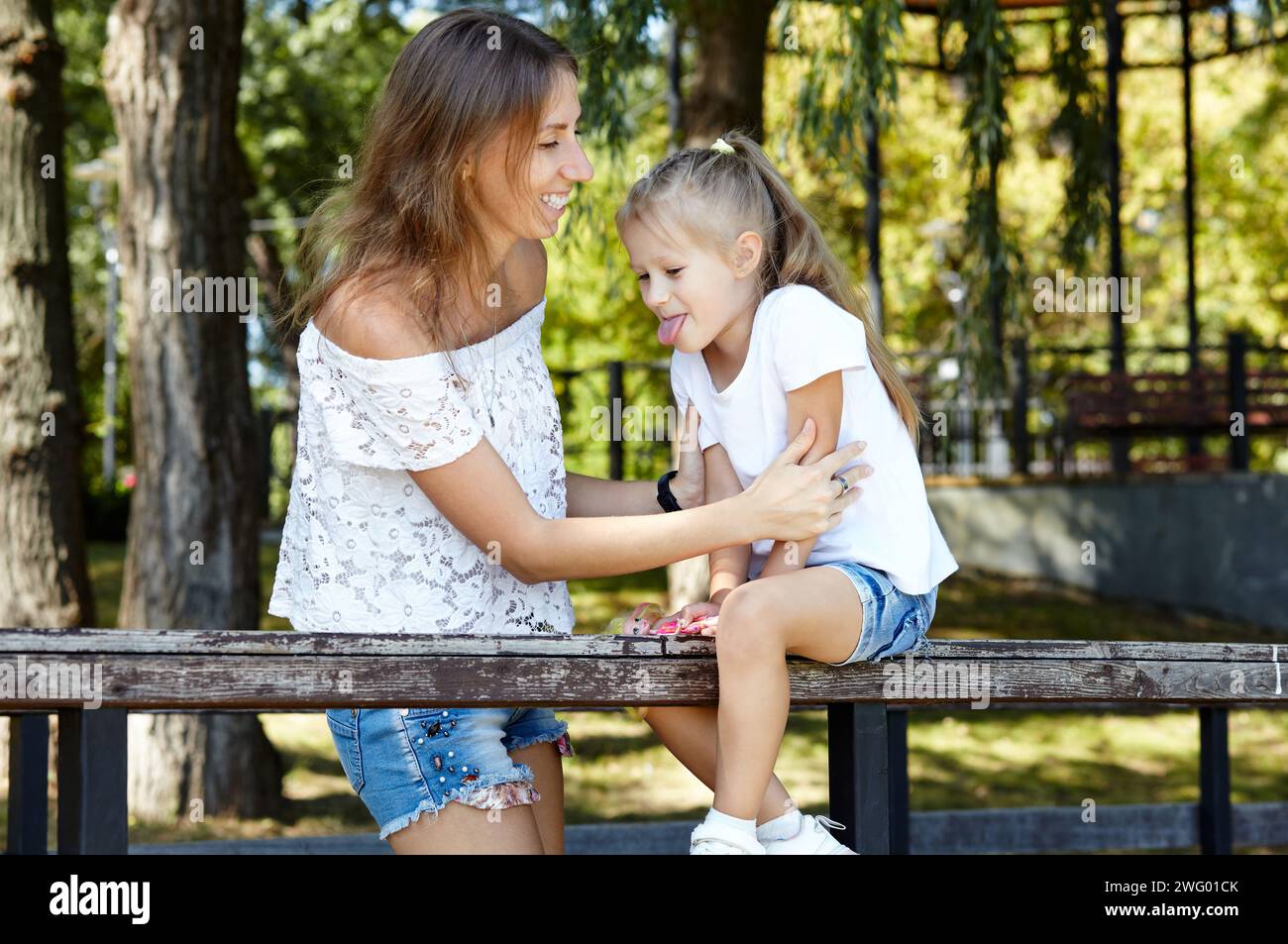 Mother and daughter walk in the summer city park. Childhood, leisure and people concept - happy ...