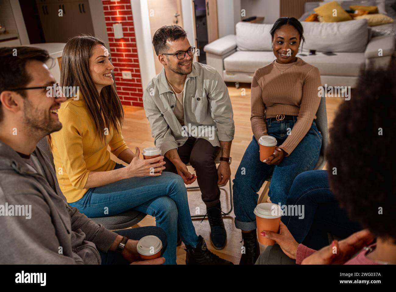 Diverse group of people sitting in circle in group therapy session ...
