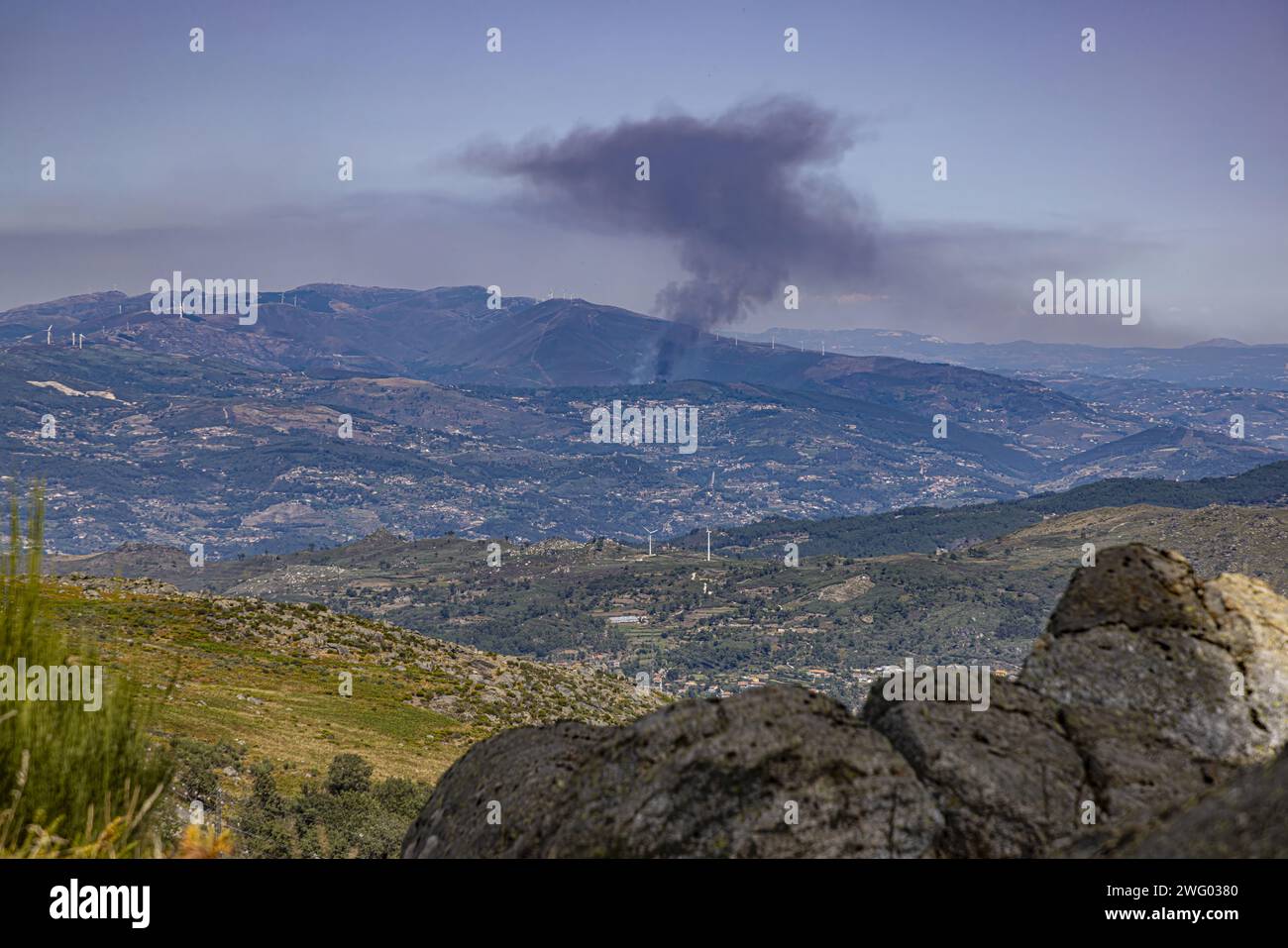 Picture of a forest fire with rising smoke from a great distance during ...